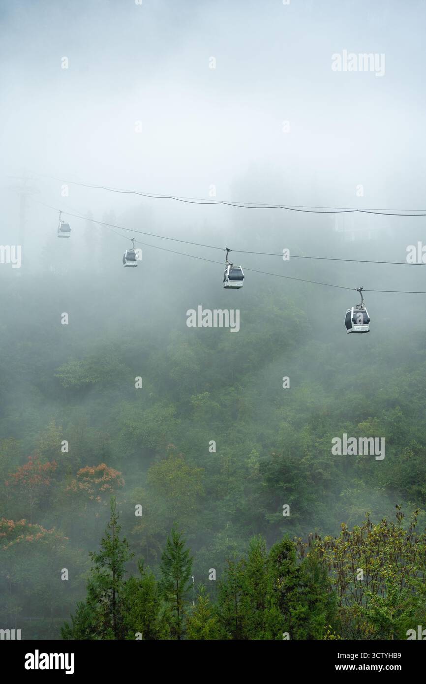 Cable cars glide through misty forest peaks near Yichang City, China ...