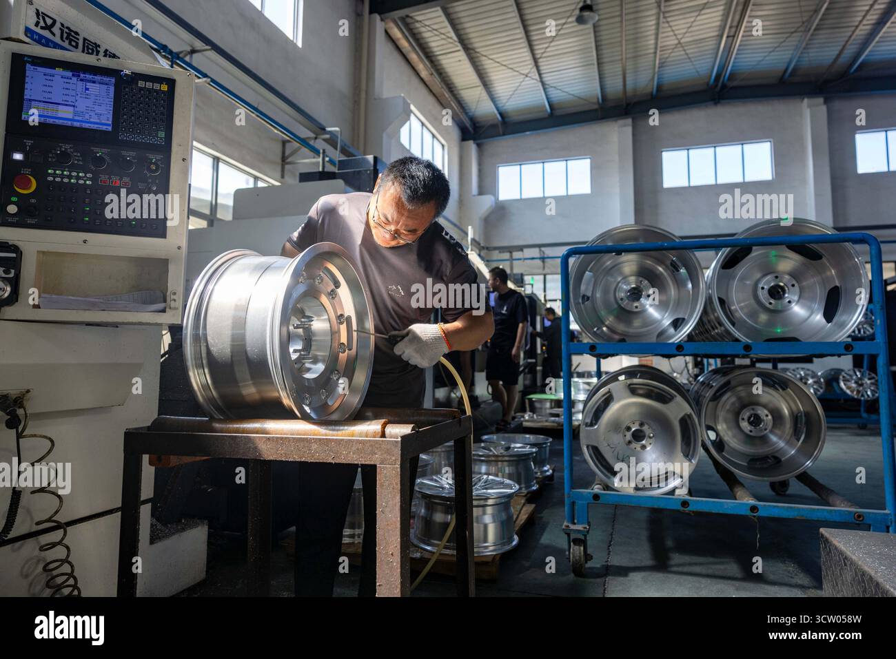 A worker works at an automotive wheel hub manufacturer in Taizhou in ...