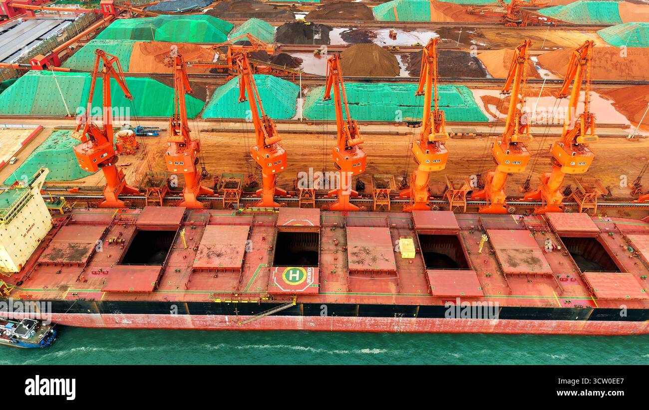 QINGDAO, CHINA - OCTOBER 9, 2025 - A cargo ship unloads imported iron ...