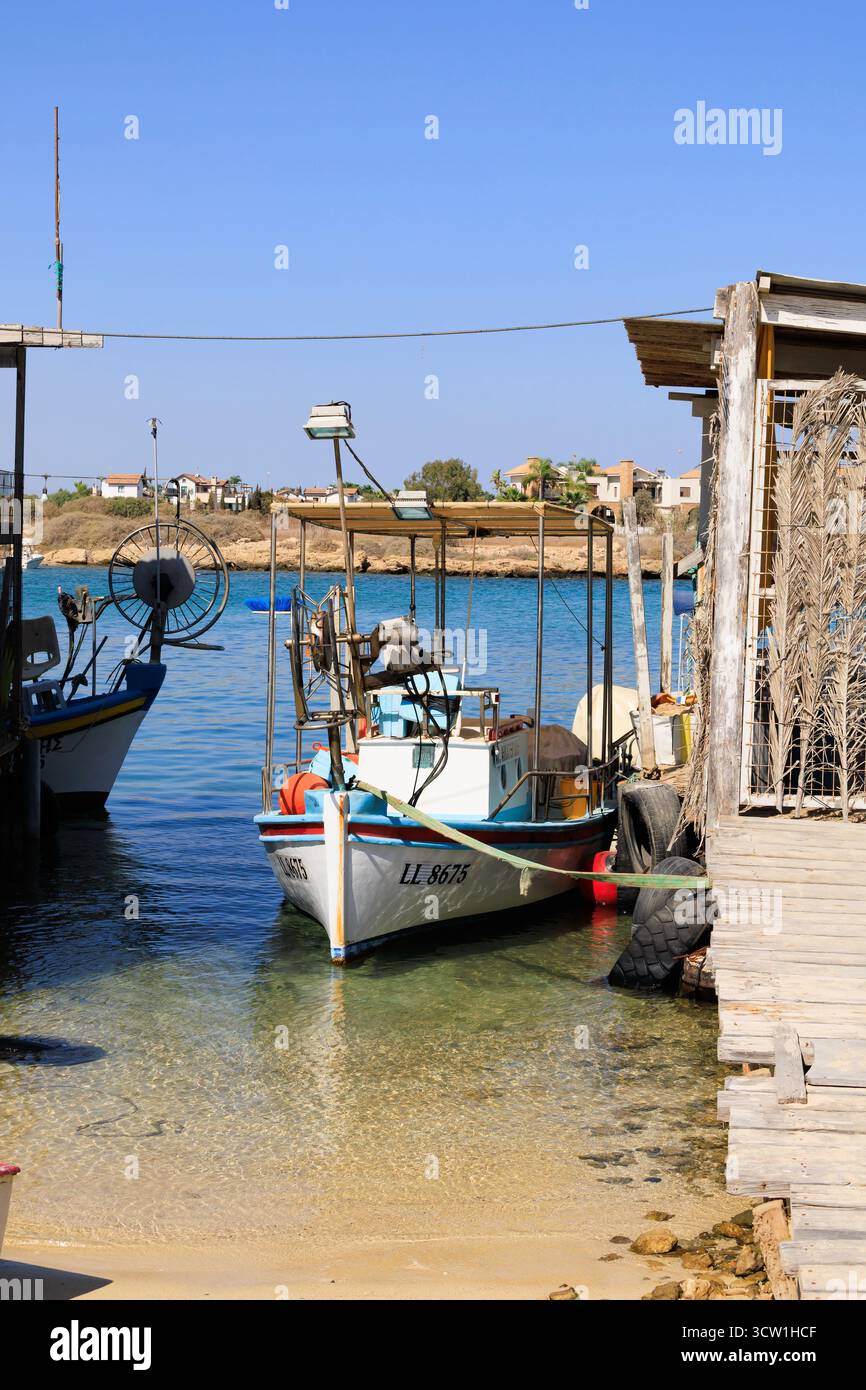 Traditional Cypriot fishing boat moored alongside ramshackle pier ...