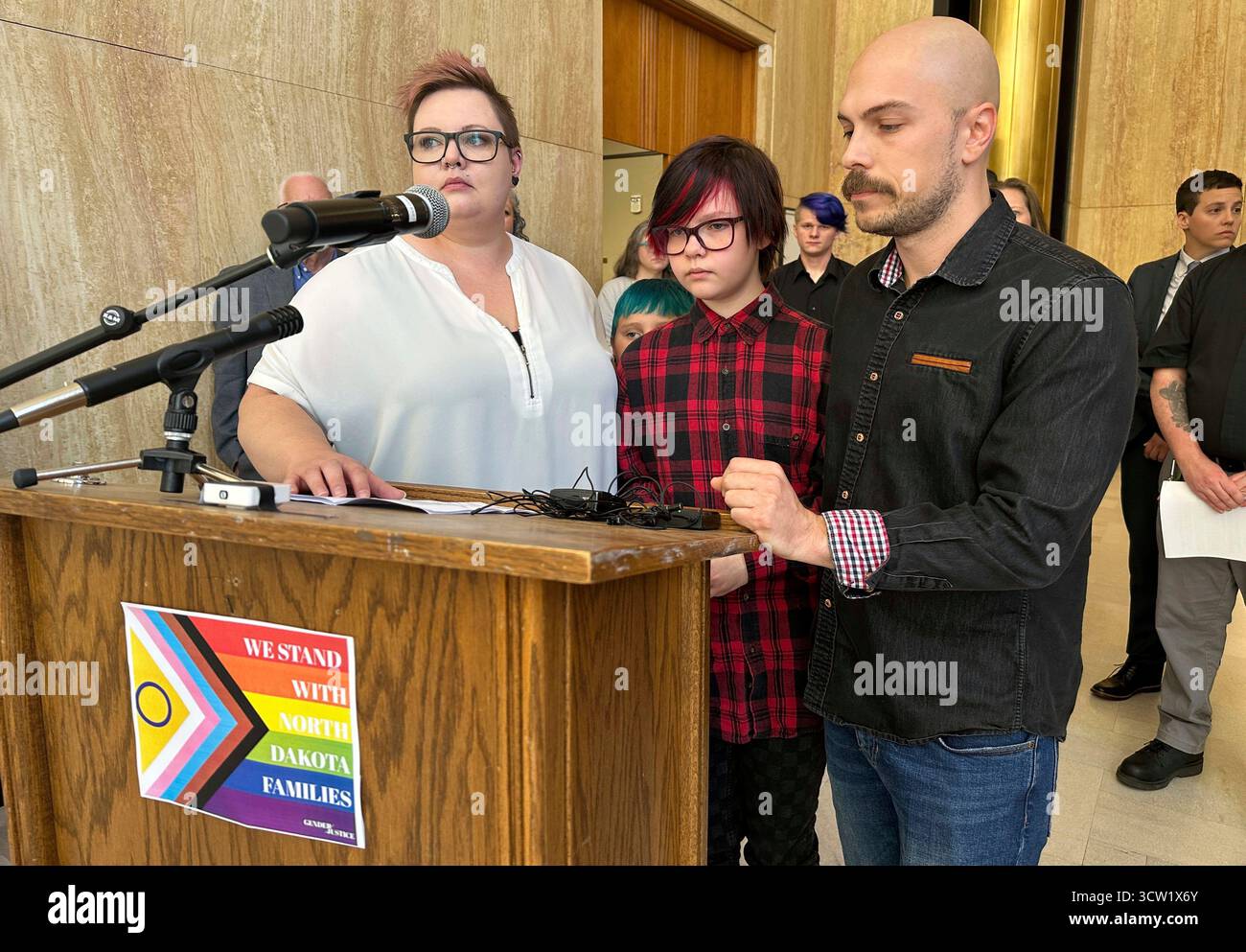 FILE - Parents Devon and Robert Dolney, stand with their child, Tate ...