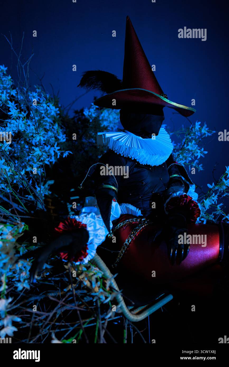Mysterious jester harlequin character in dark costume and tall hat ...