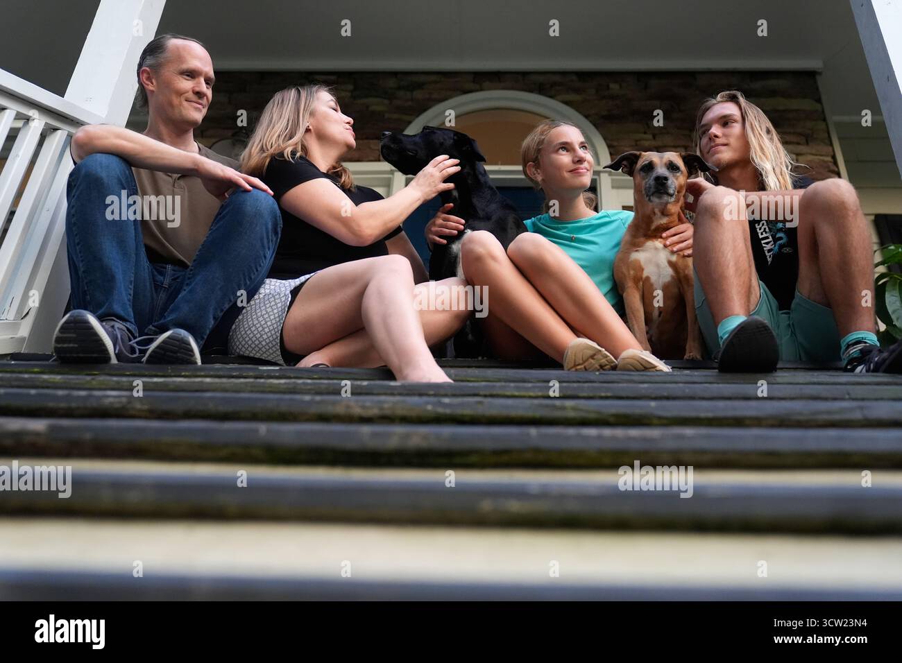 Meaghan and Chris Marr pose with their children and dogs for a ...