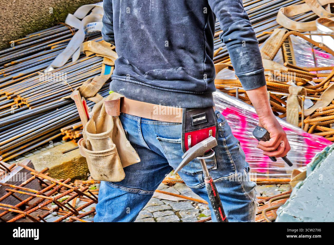 Hektik auf der Baustelle. Der Bauarbeiter zwischen den Moniereisen ...