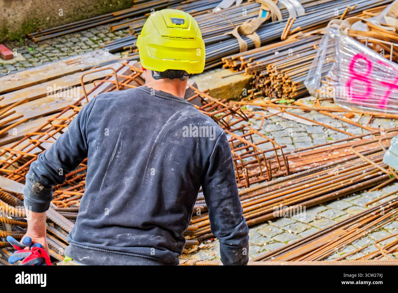 Hektik auf der Baustelle. Der Bauarbeiter zwischen den Moniereisen ...