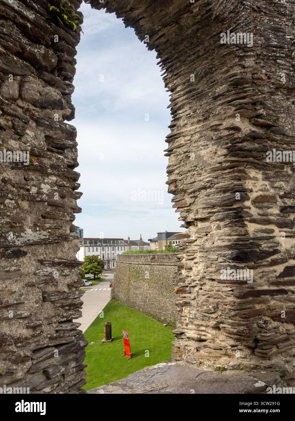 Historic roman walls in Lugo, Spain, framing a view of modern buildings ...