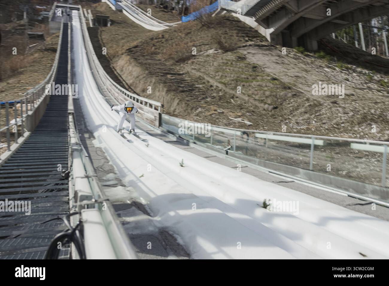 Ski jumper in the inrun, from the top of the ski jump, skiing down in a ...