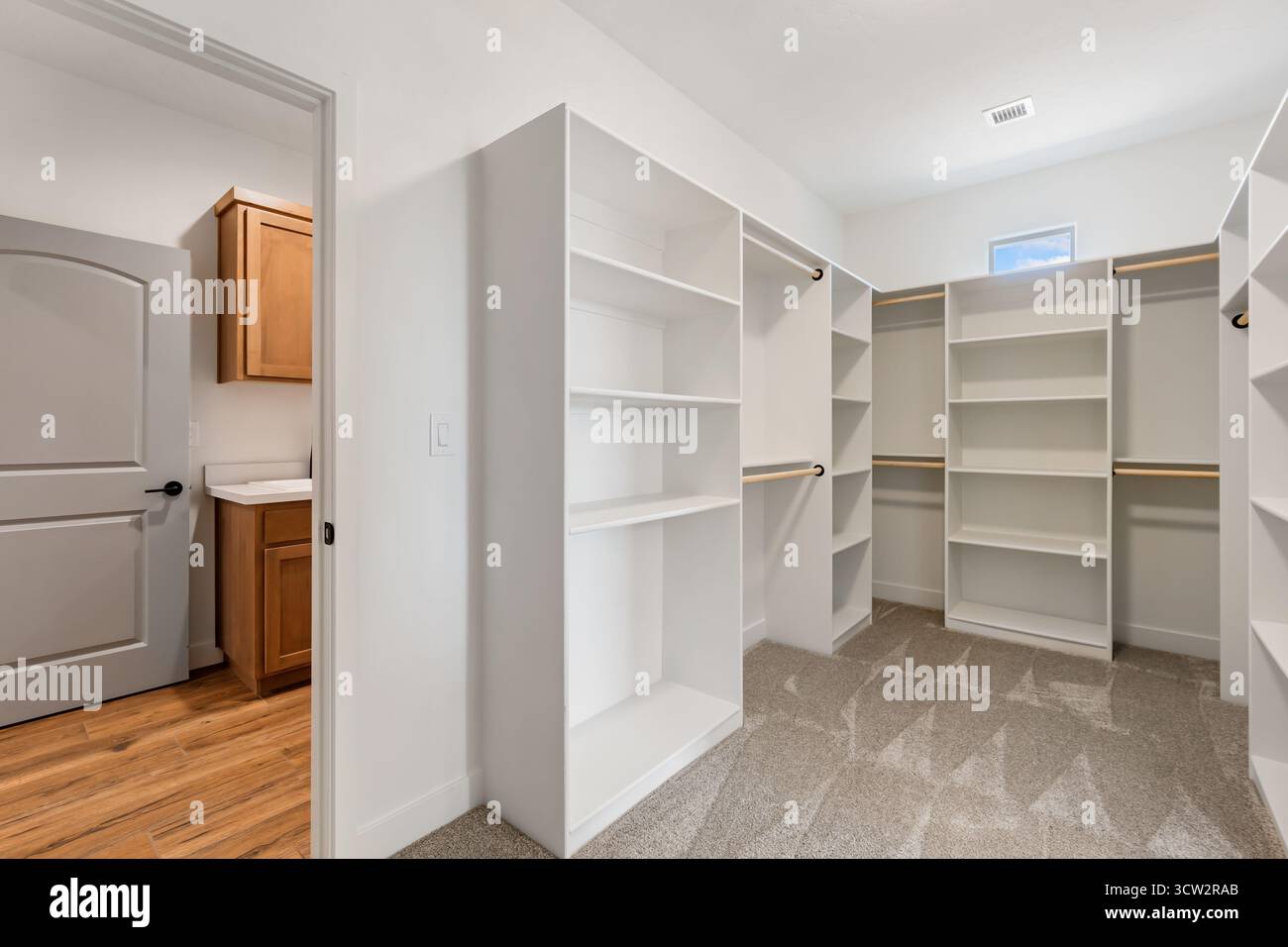 A walkin closet with shelves and a laundry room behind Stock Photo - Alamy