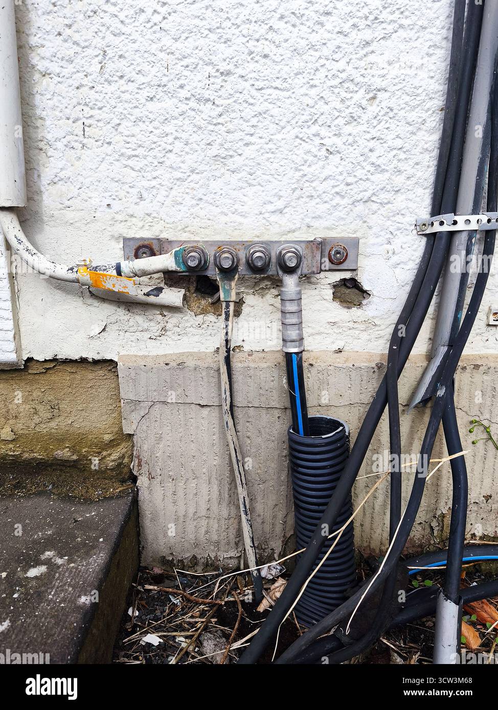 Electrical grounding connection terminal outside on rough white stucco ...