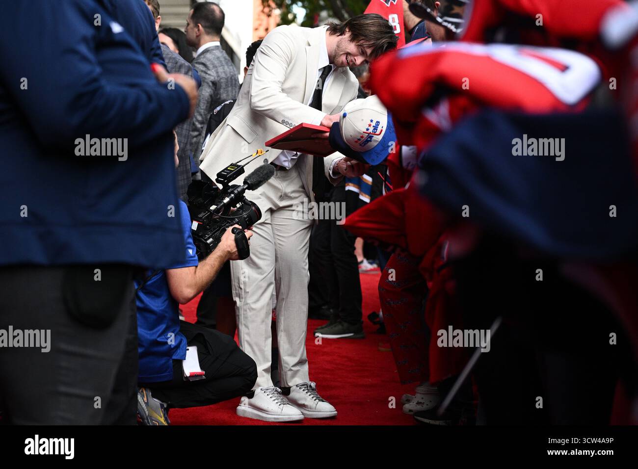 Washington Capitals center Connor McMichael (24) walks the red carpet ...