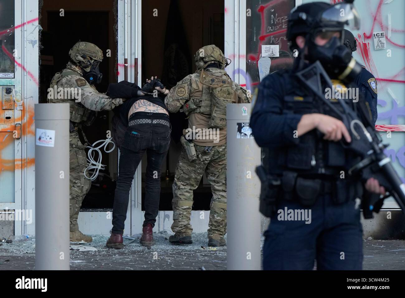 FILE - U.S. Customs and Border Protection agents detain a man outside ...