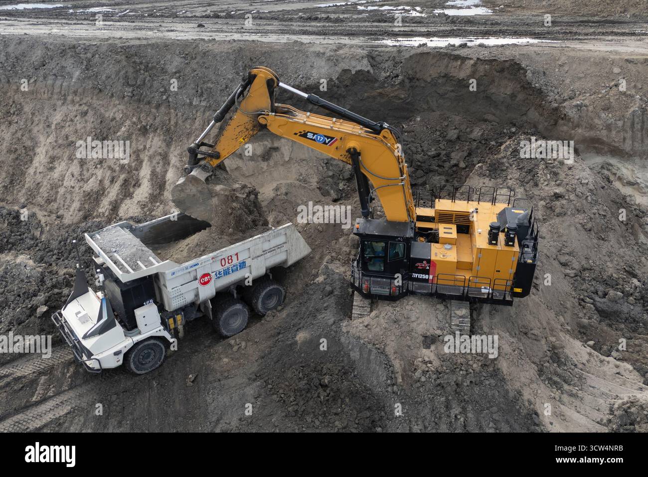 An excavator loads an autonomous mining truck in the Huaneng Yimin open ...