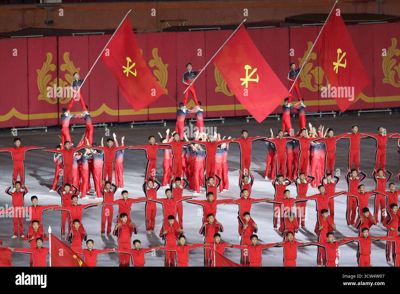 People wave the party flags during the ceremony marking the 80th ...