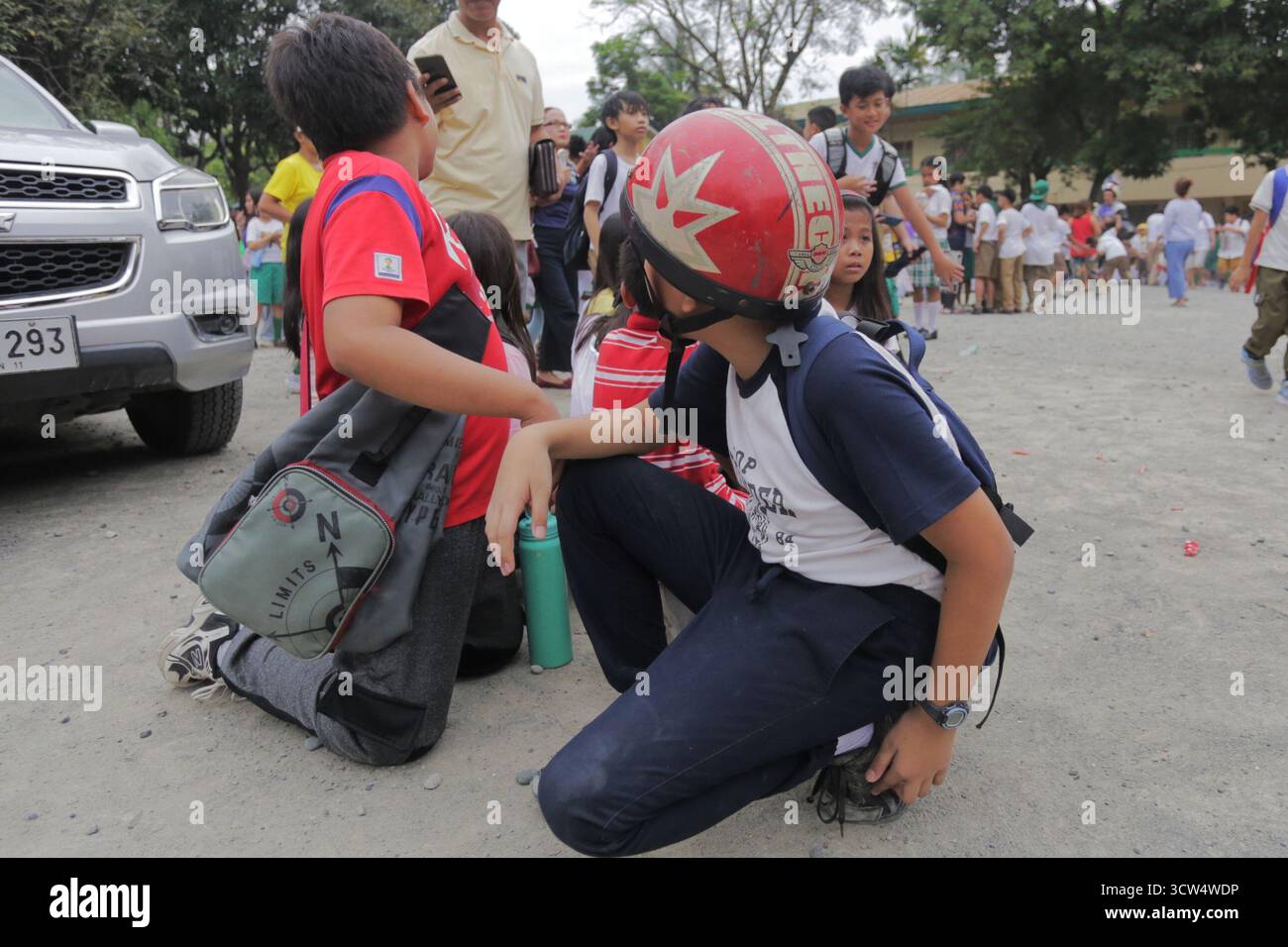 Children evacuate a school after a strong earthquake in Davao City ...