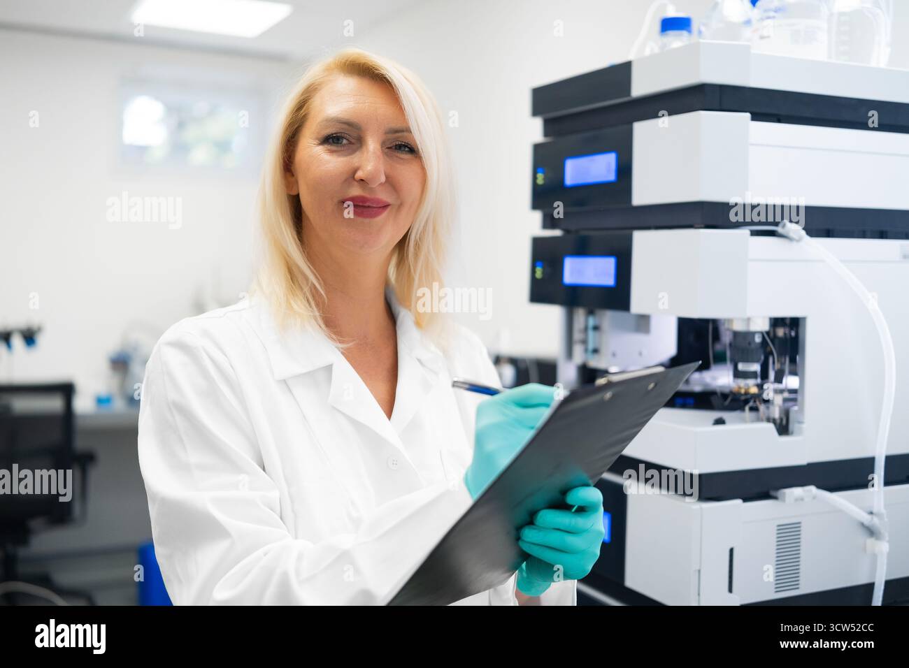 Experienced woman researcher recording chromatography results during ...