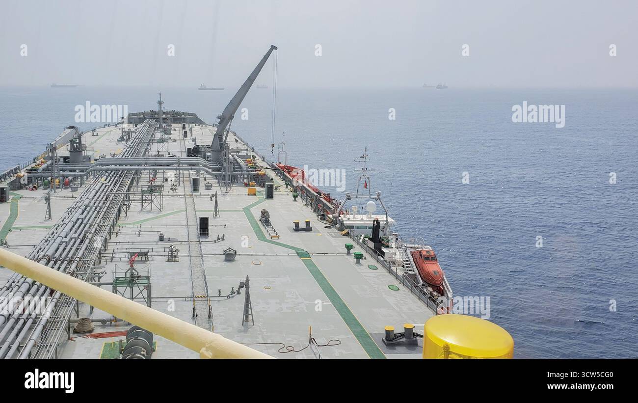 Huge oil tanker. Panorama of the cargo deck with pipelines, crane and ...