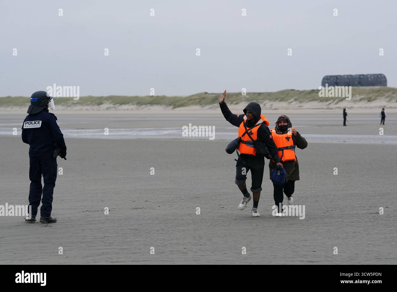 French police officers, holding cans of a spray substance, talk with ...