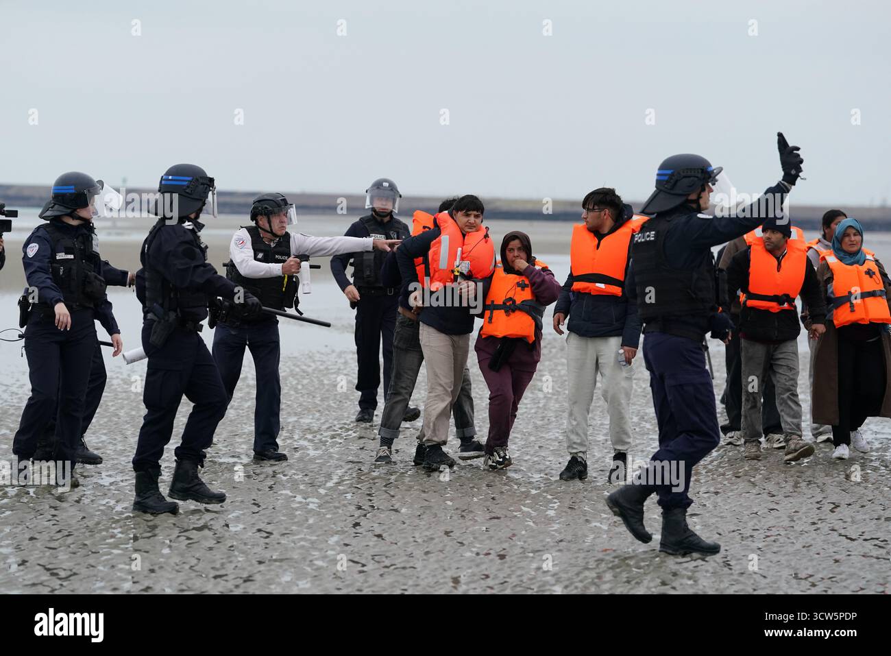 French police officers, holding cans of a spray substance, talk with ...