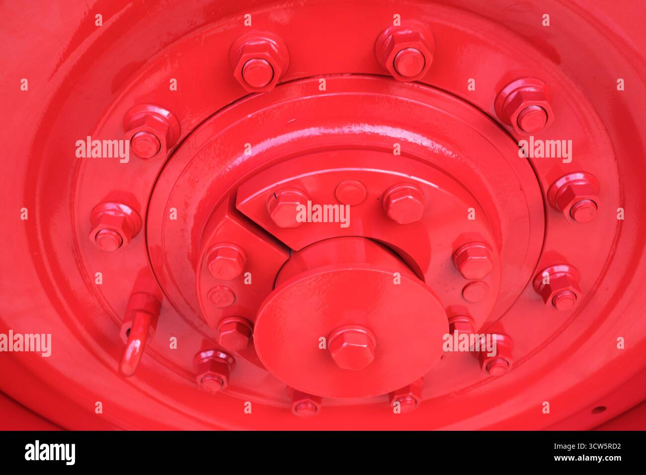 Bright red industrial machinery component showing bolts and circular ...