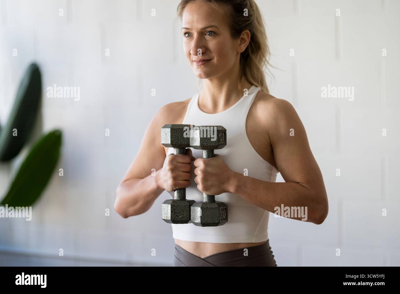 Woman doing biceps exercise dumbbells hi-res stock photography and ...