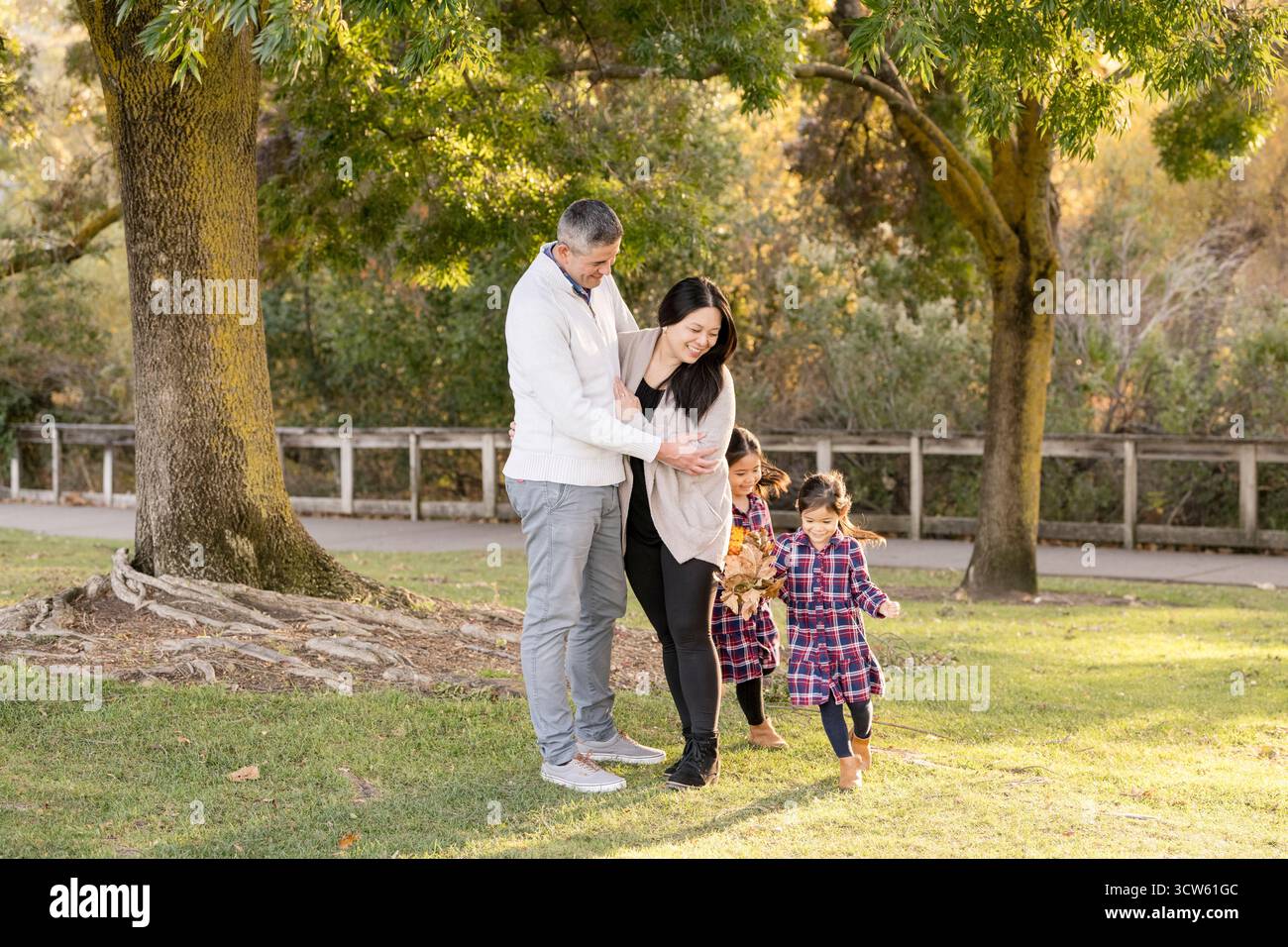 Parents smiling at kids running around them Stock Photo - Alamy