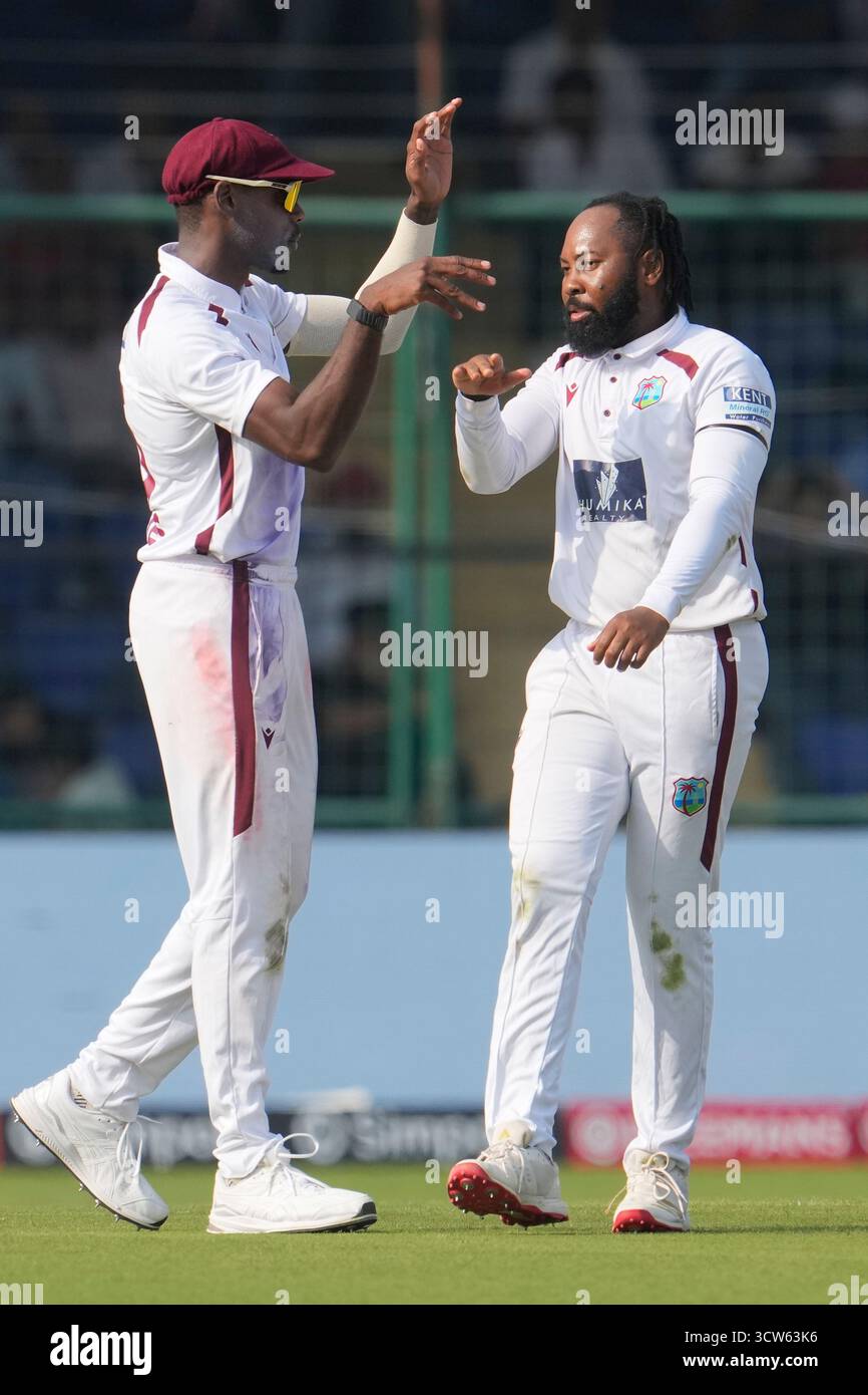 West Indies' Jomel Warrican, right, celebrates the dismissal of India's ...