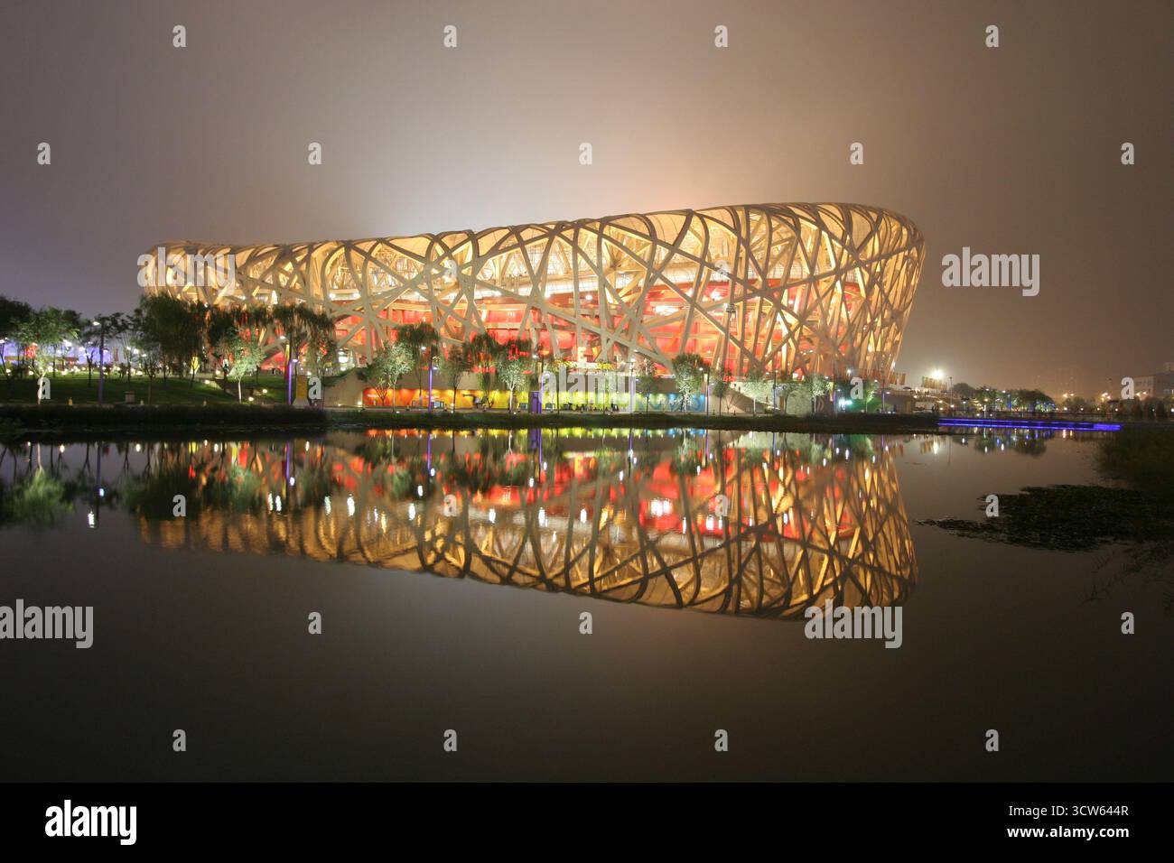 The iconic National Stadium illuminated at night, its unique woven ...