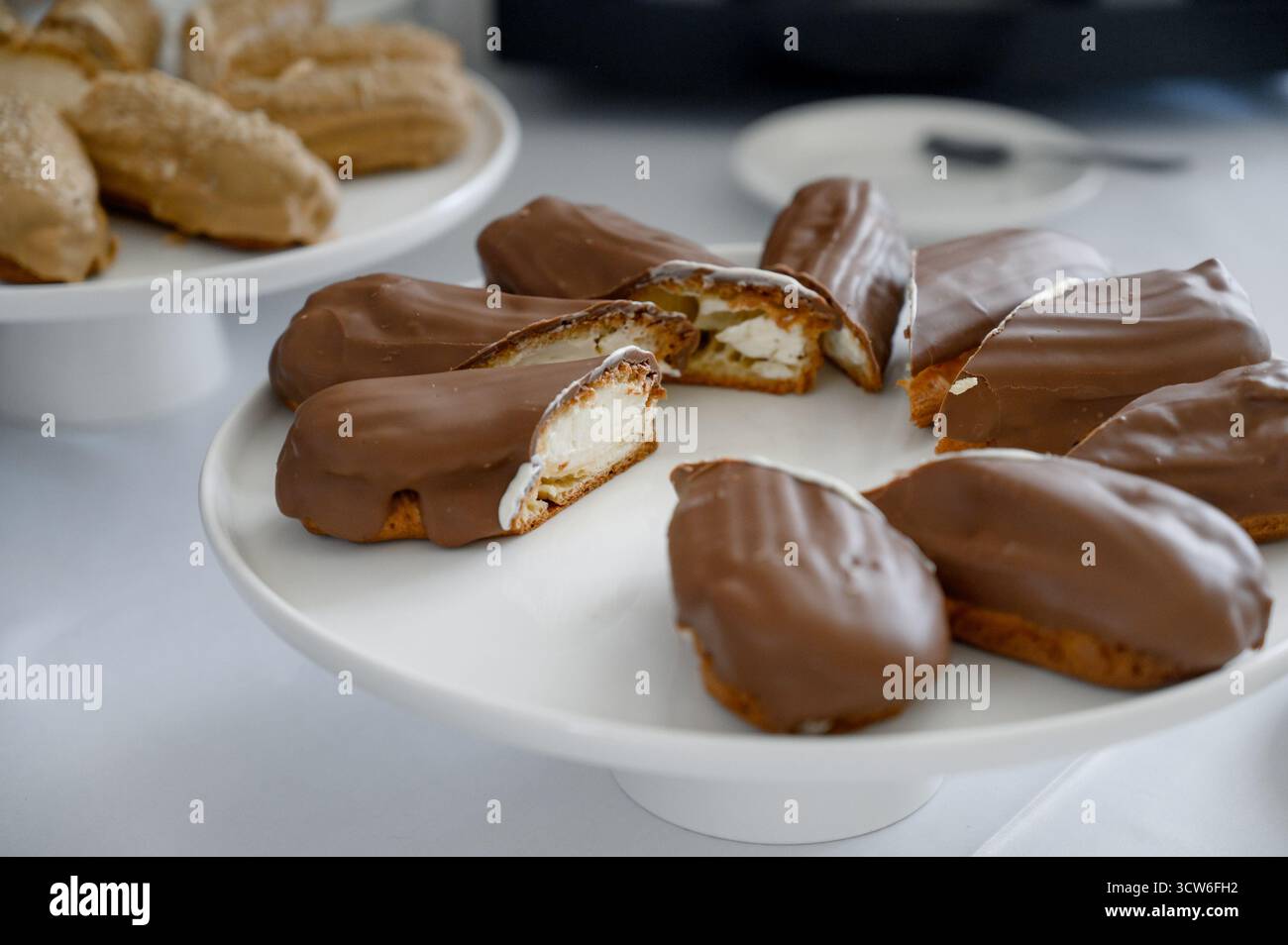 Bouche or Potato cakes in milk chocolate on a white round buffet stand ...