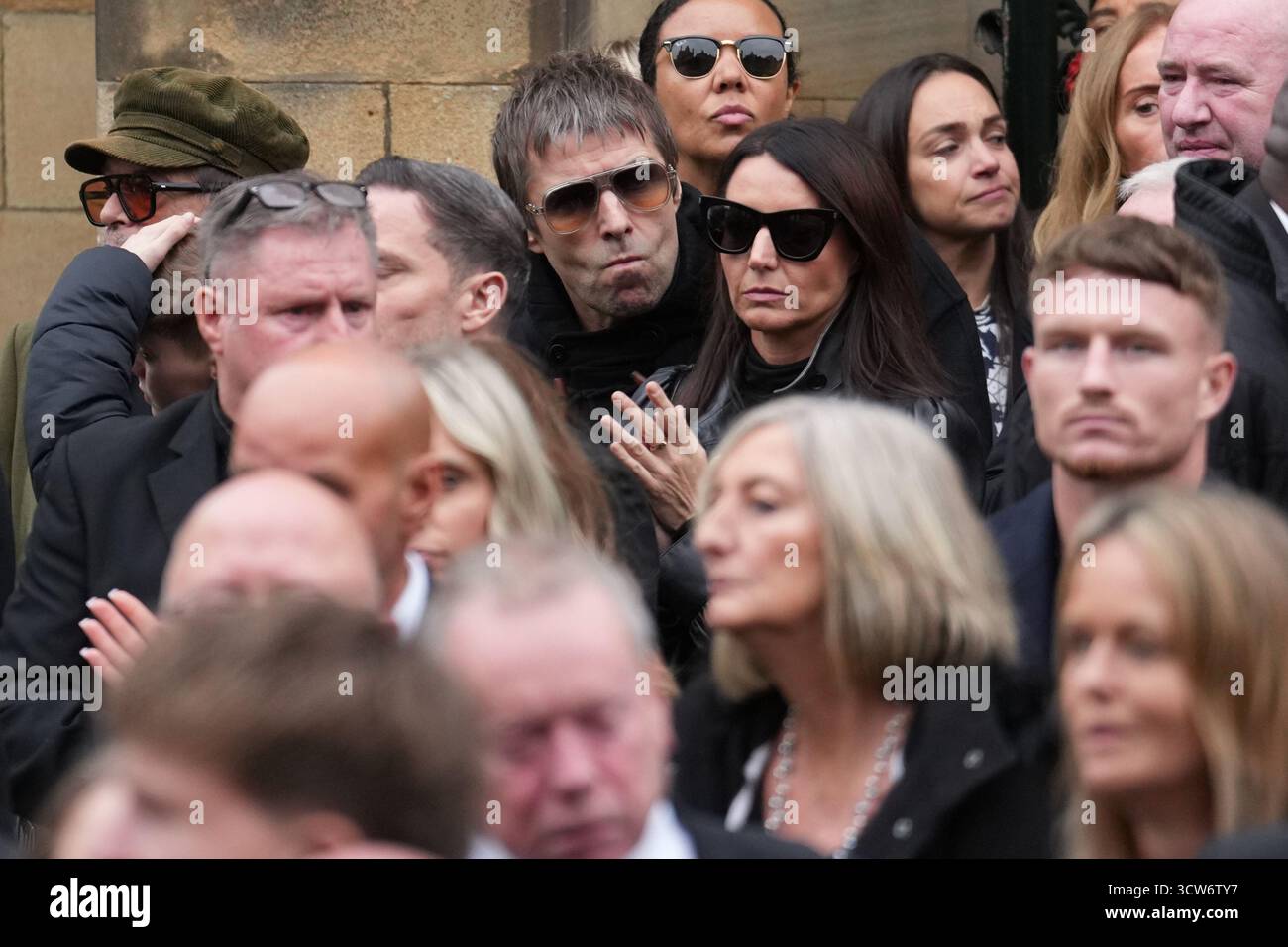 Liam Gallagher, top centre, of the band Oasis attends the funeral for ...