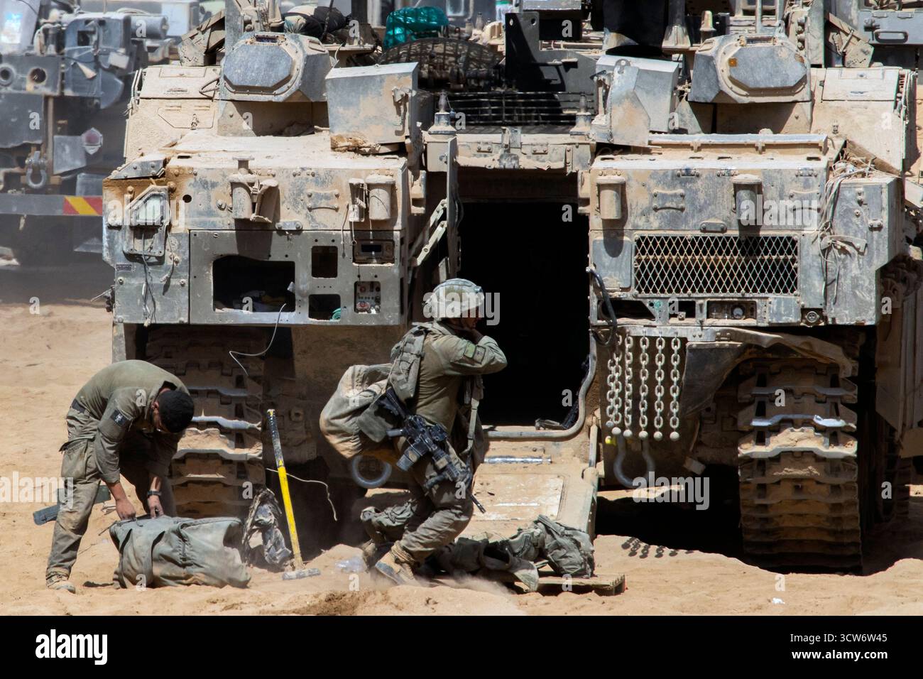 Israeli IDF soldiers collect personal gear as they leave their tank in ...
