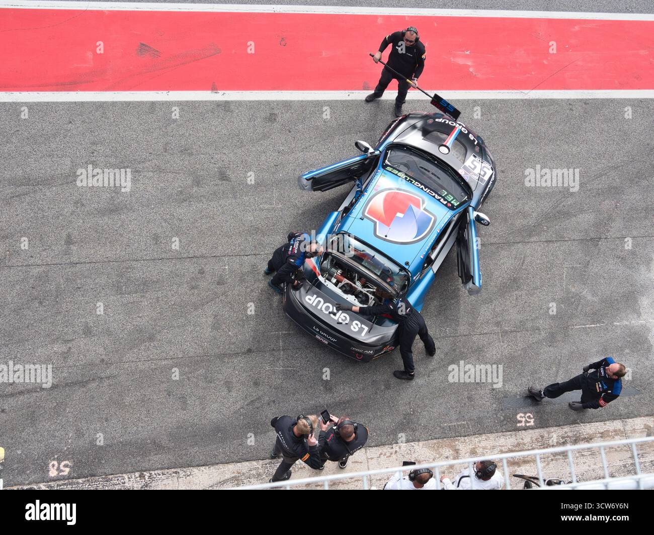 Pit Crew Working on Race Car Overhead - High-angle view of the pit crew ...
