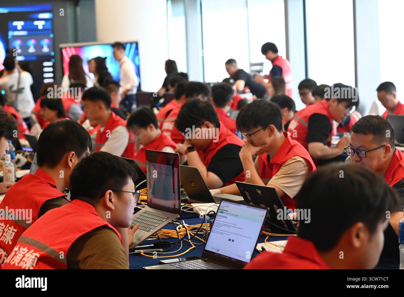 People participating in the cybersecurity exercise using computers ...