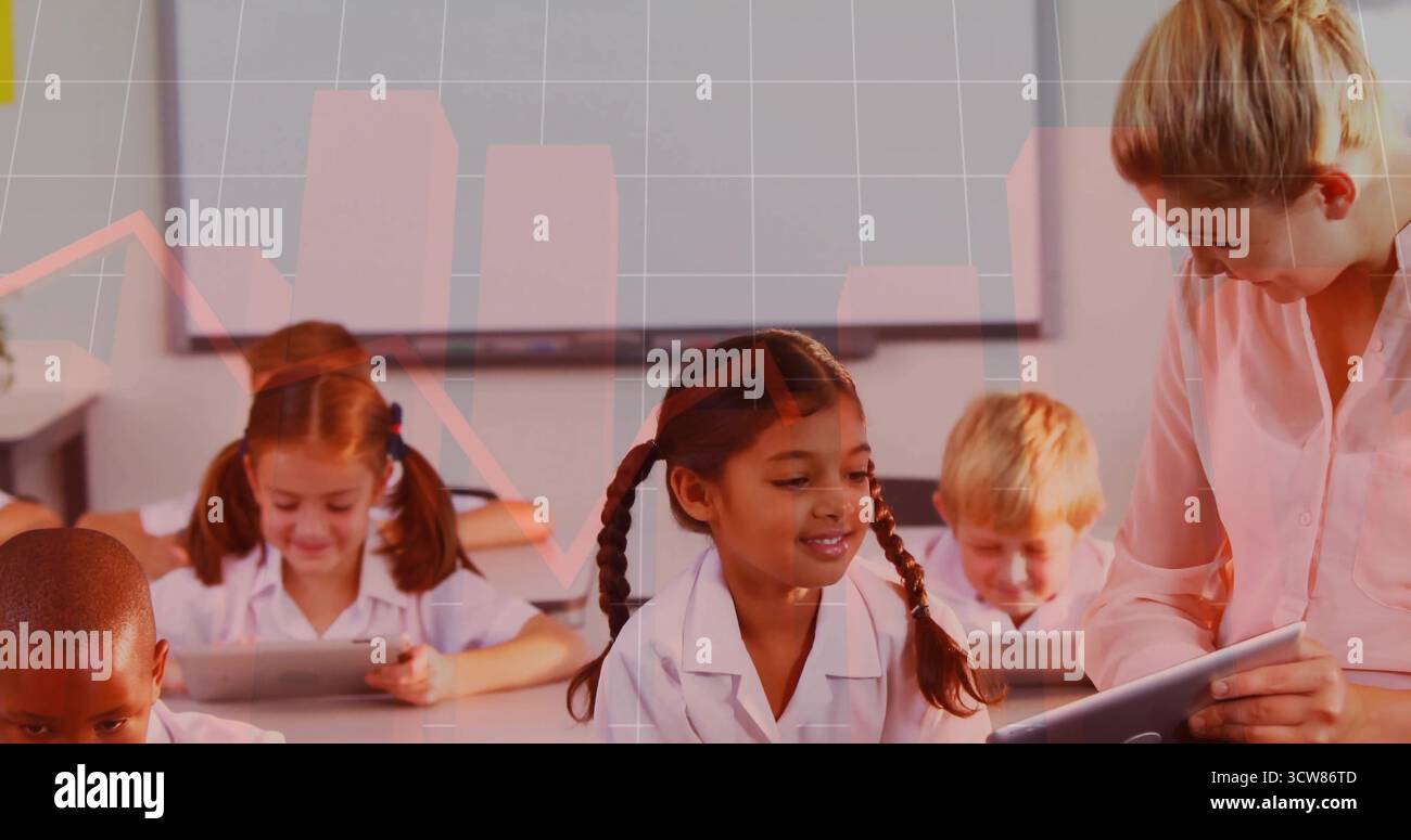 Leaning teacher guiding girl tapping tablet at student desk in ...