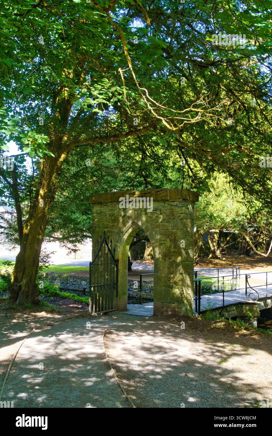 Stone arched gateway entrance to a beautiful garden in Ireland, under ...