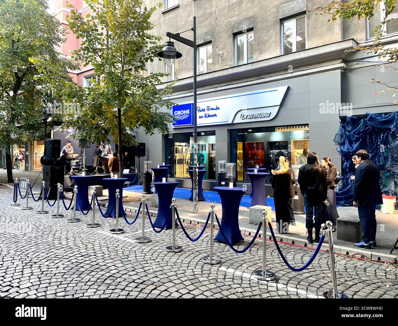 Shop opening and live event preparations on cobbled street in downtown ...