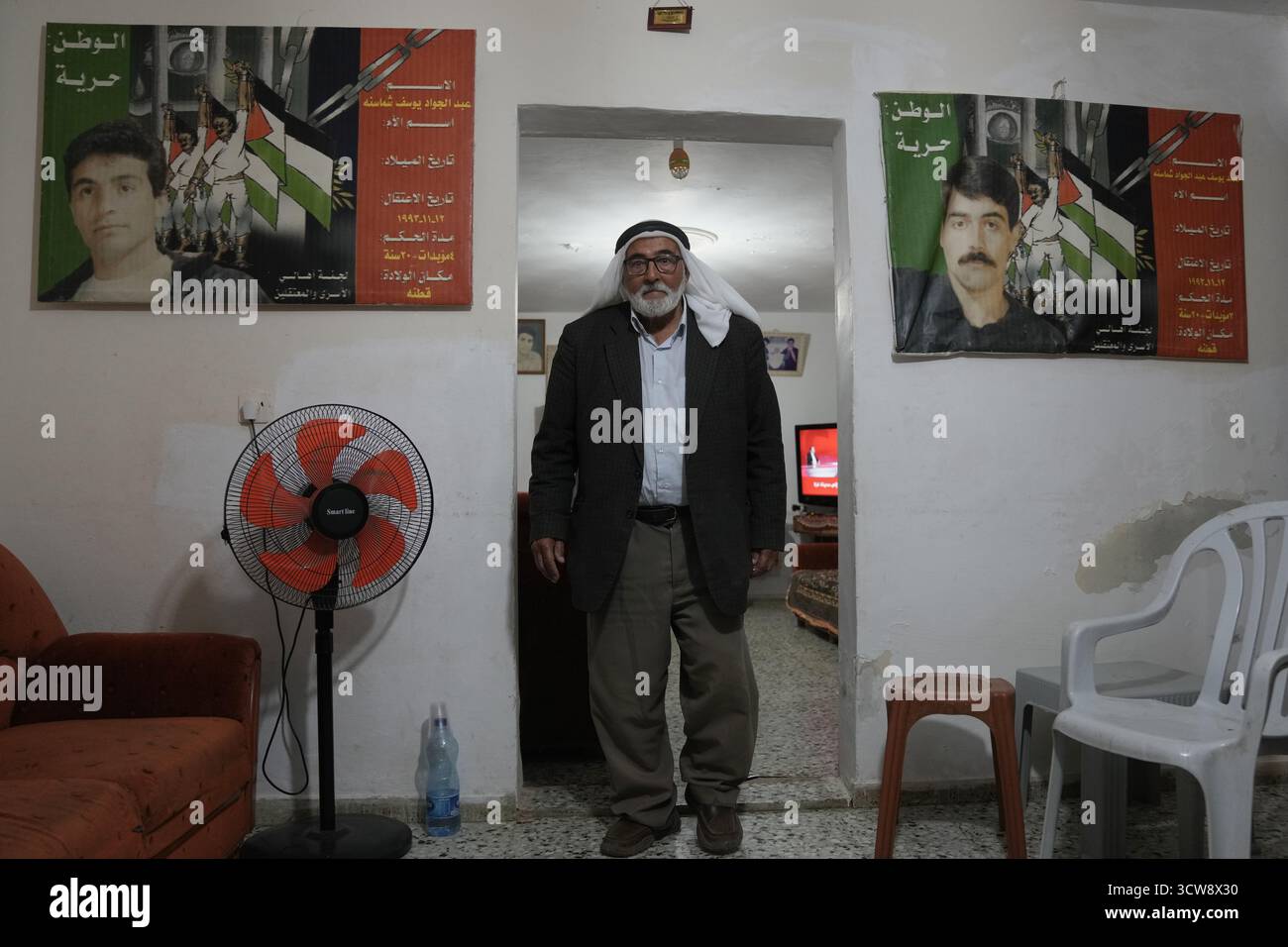 Yousef Shamasneh, 83, passes by posters of his two imprisoned sons ...