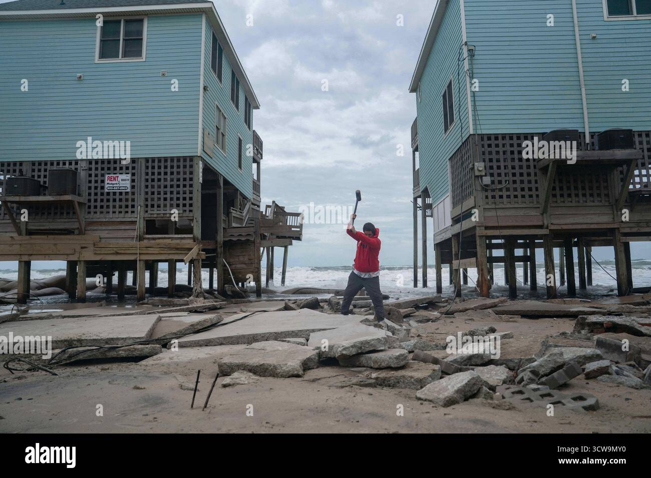 Justin Hayes breaks up concrete that used to make up the driveway to a ...