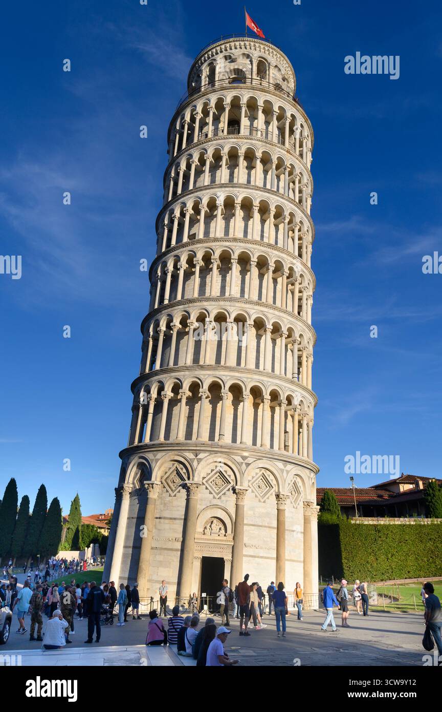 Iconic Leaning Tower of Pisa stands with a crowd of visitors in a ...