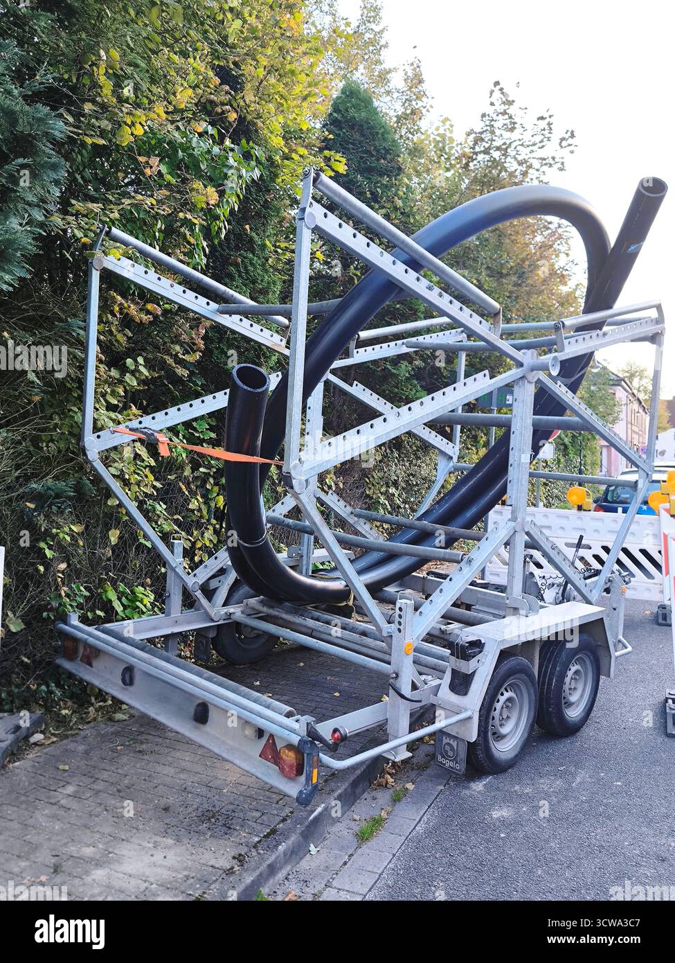 A trailer parked on the side of the road, with the remaining frame ...