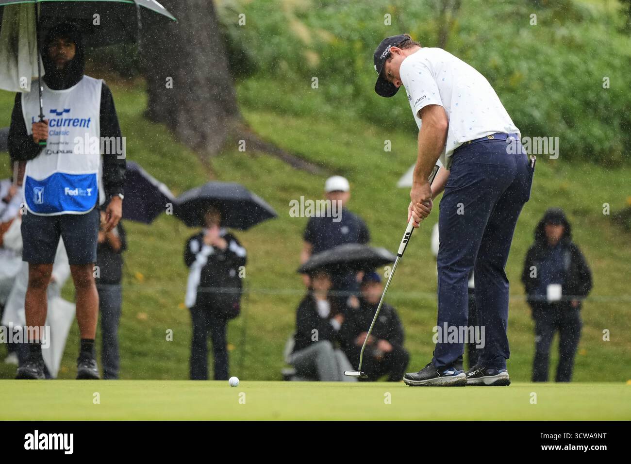Max Greyserman, of the U.S., makes a putter shot on the second hole ...