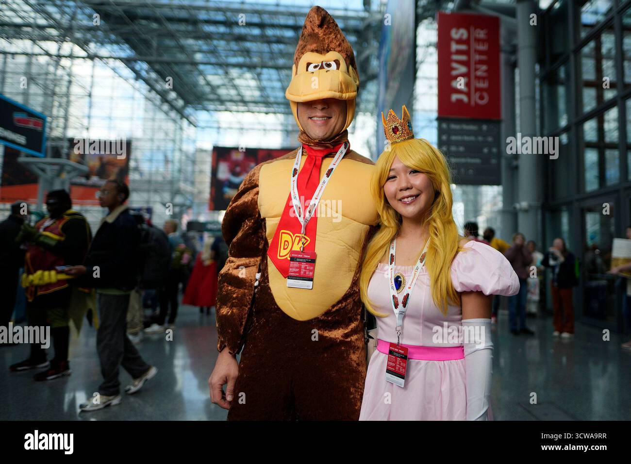 Attendees dressed as Donkey Kong and Princess Peach pose during New ...