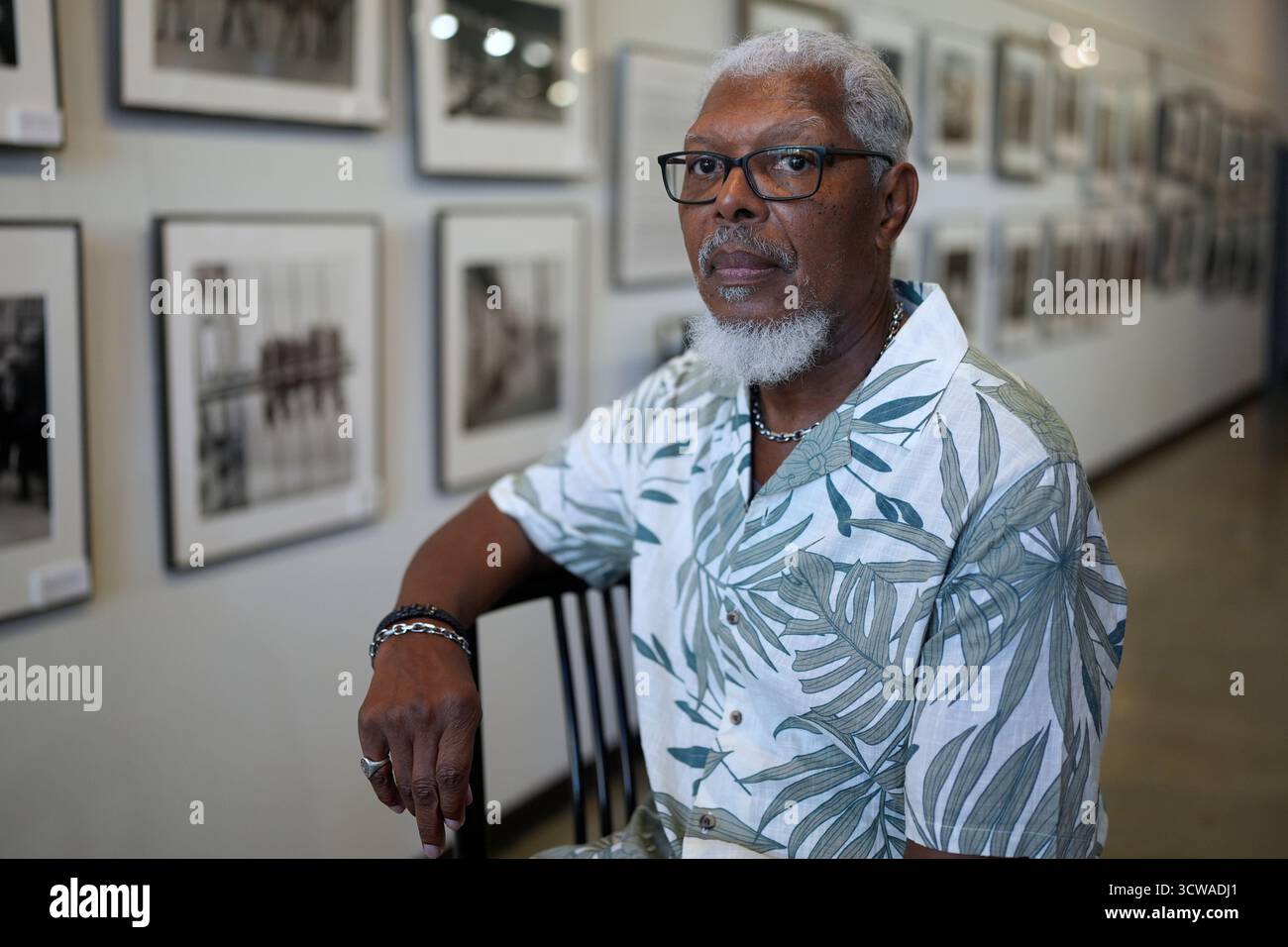 Joe Calhoun poses in front of historical photos of the National Guard ...