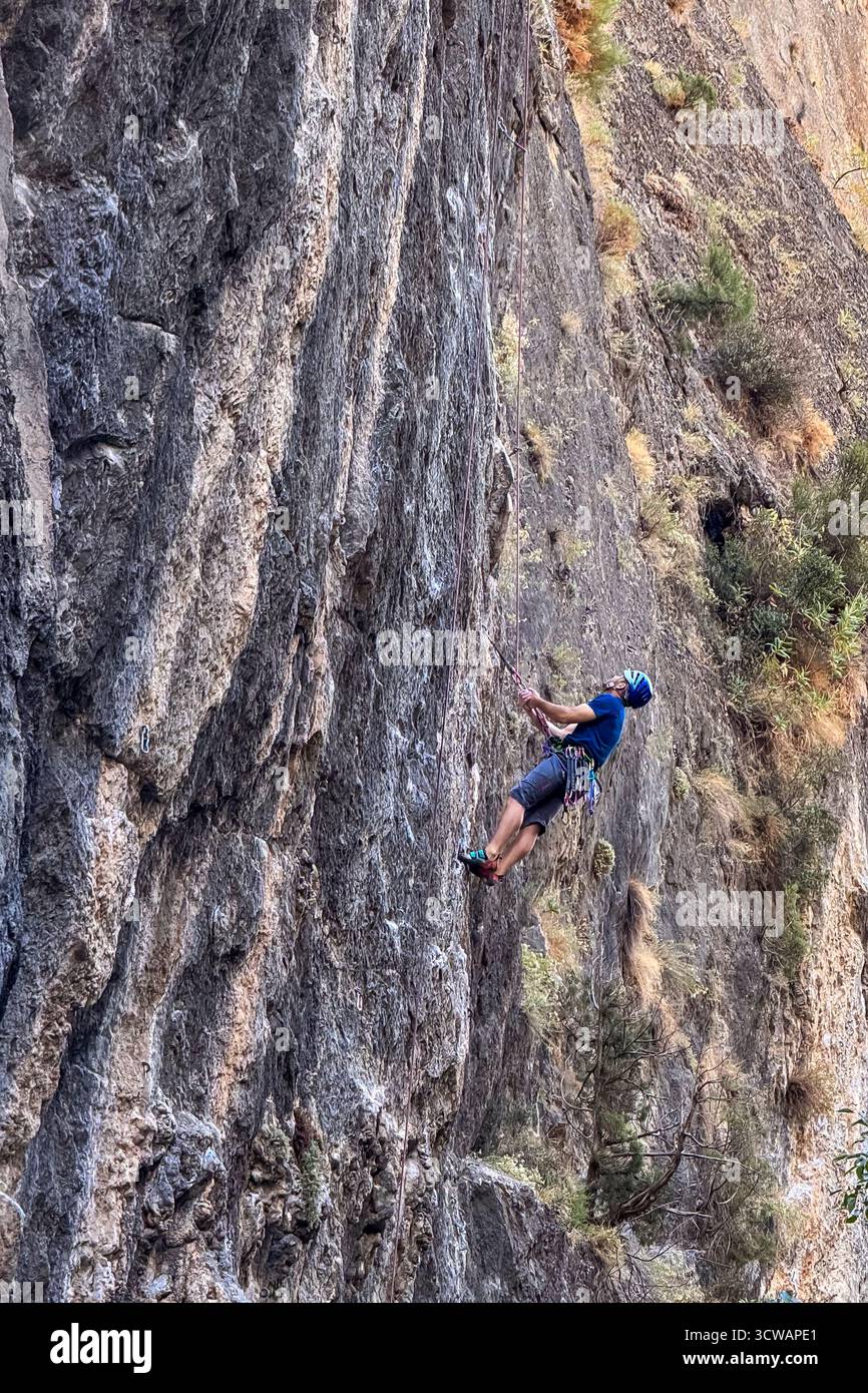 Climber scaling a rock face Stock Photo - Alamy