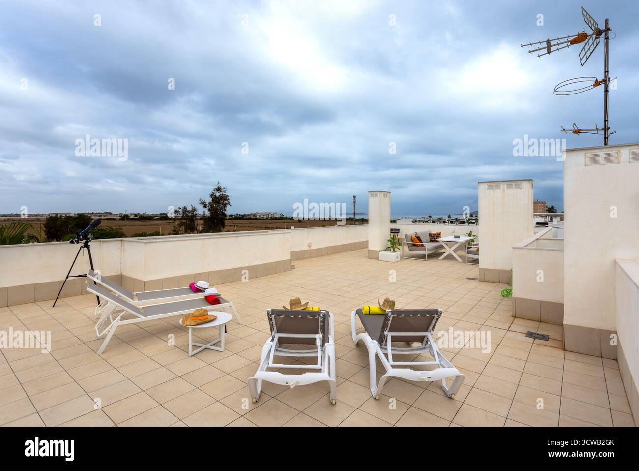 Expansive rooftop terrace with sun loungers, seating, and open sky ...