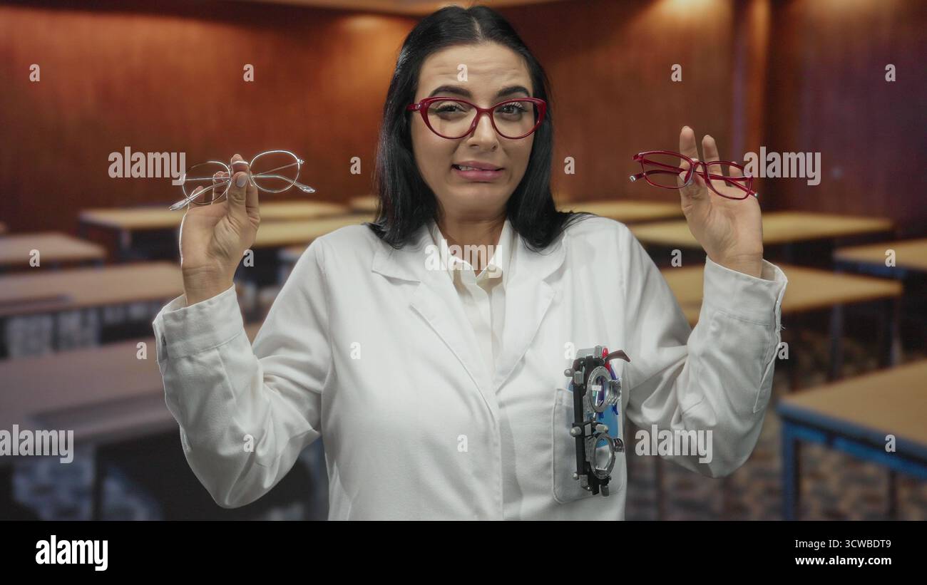 Woman optician in classroom holding glasses wearing uniform and glasses ...