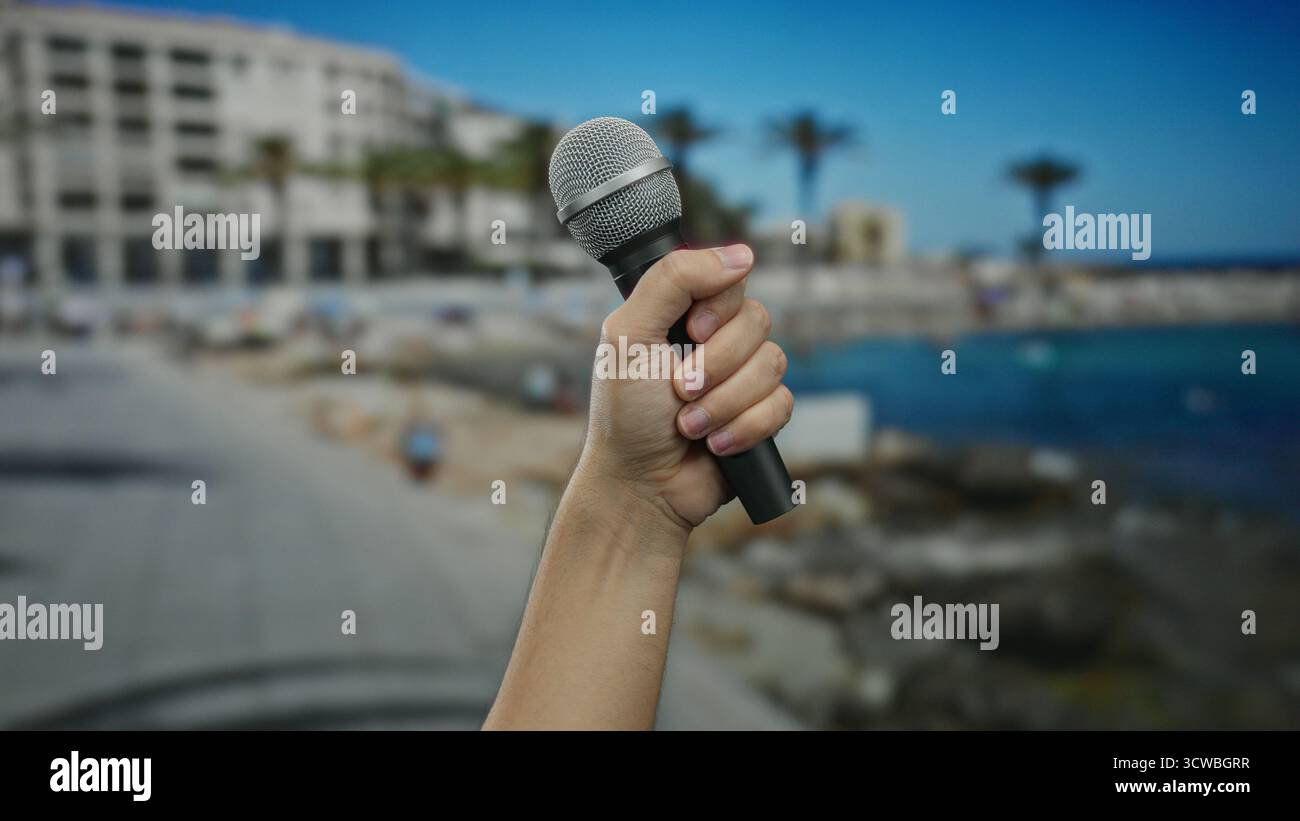 Man holding microphone seaside background hi-res stock photography and ...