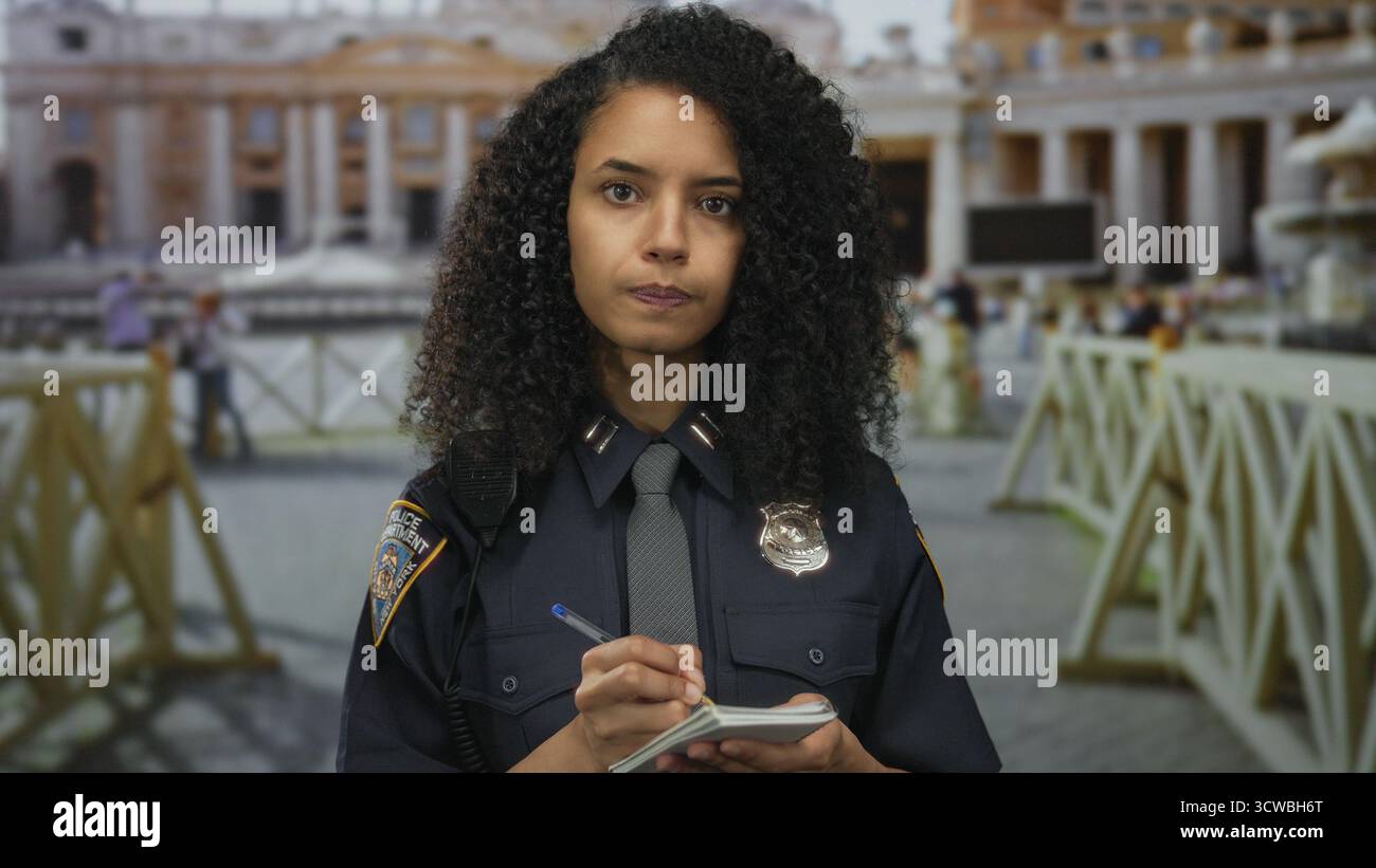 Young hispanic female police officer in uniform writing notes outdoors ...