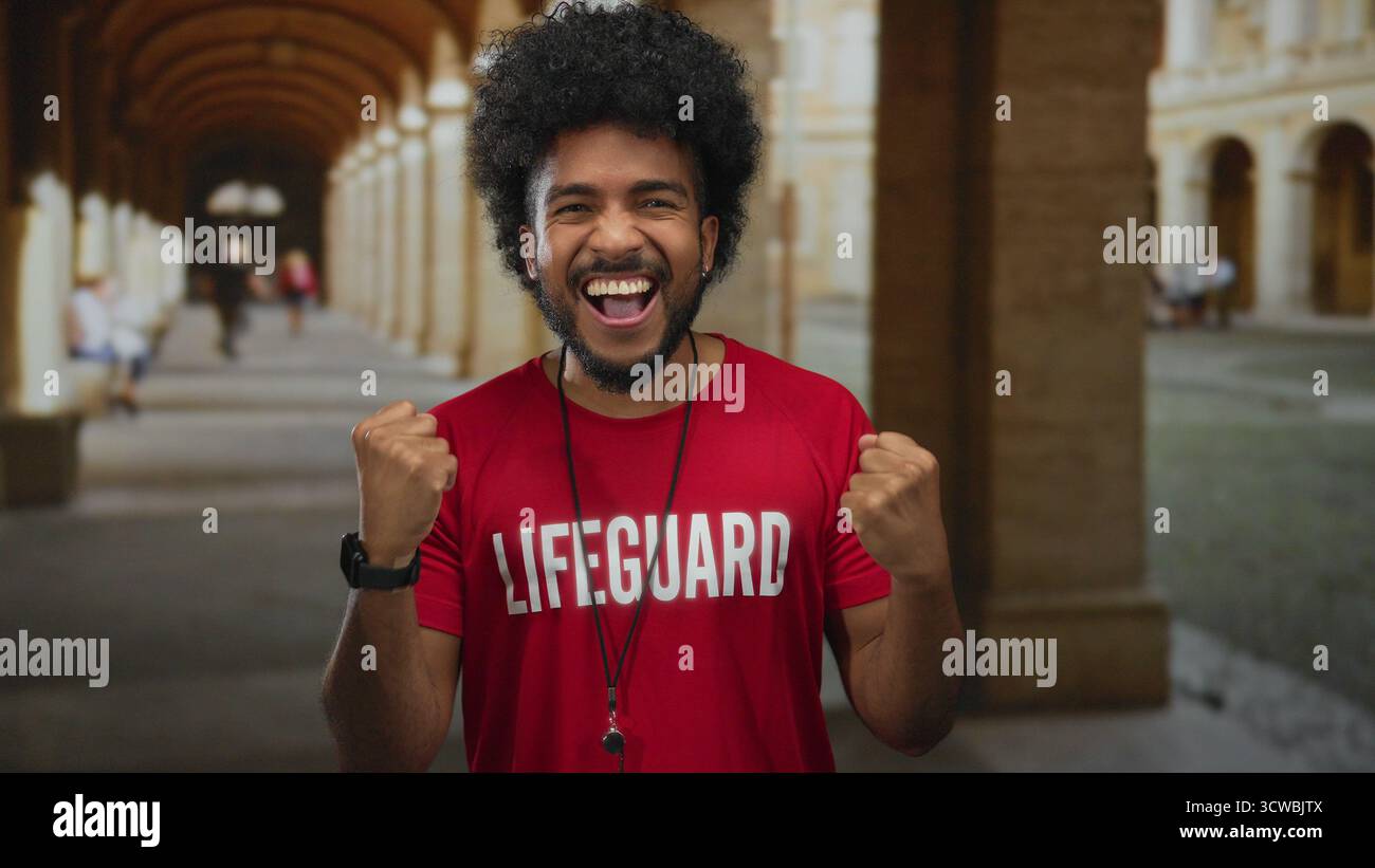 Smiling lifeguard man stands joyfully in an old university courtyard ...