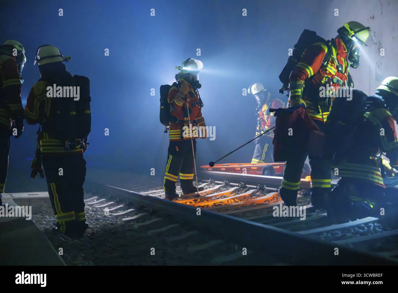 Firefighters working with equipment on tracks in a tunnel, firefighting ...