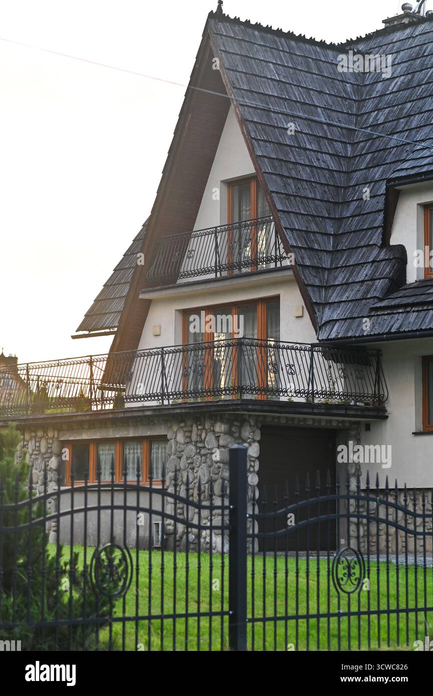 Modern private house with steep roof and fenced yard in residential ...